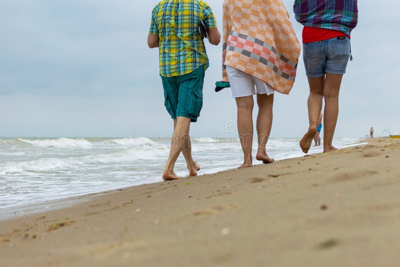 Unrecognizable People, Three People are Walking Along the Sea Coast ...