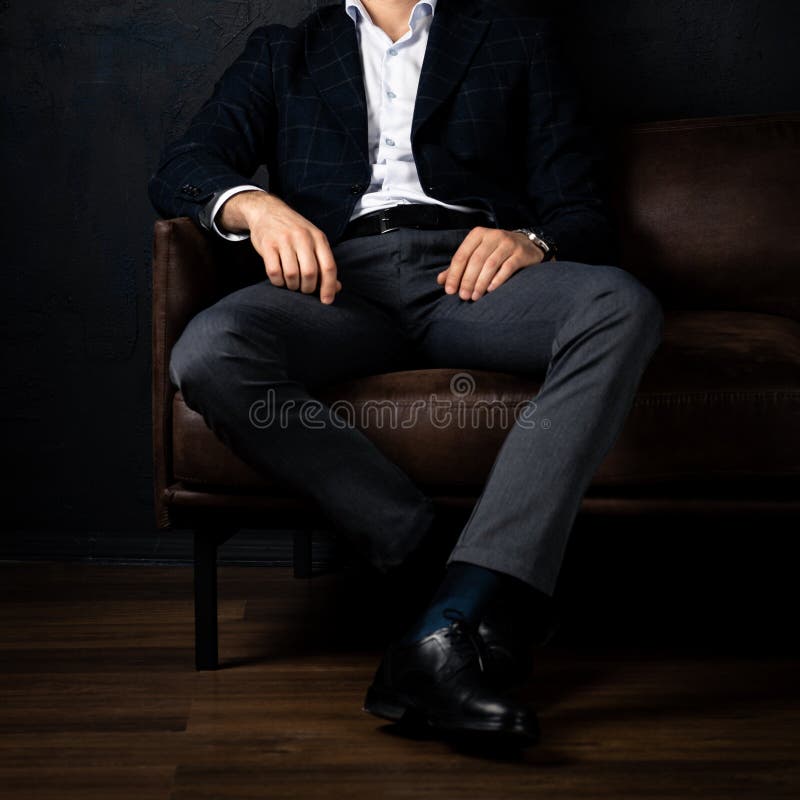 Unrecognizable Stylish Macho Man Sits Relaxed on the Sofa in the Dark ...