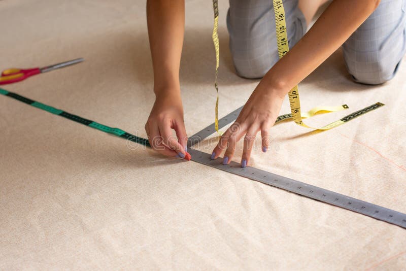 A Woman is Measuring a Piece of Fabric Using Rules Stock Photo - Image ...