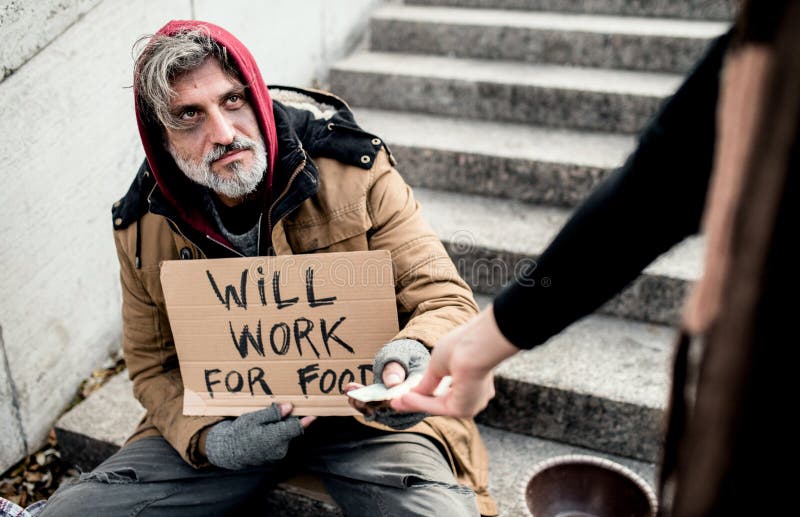 Unrecognizable Woman Giving Money To Homeless Beggar Man Sitting In