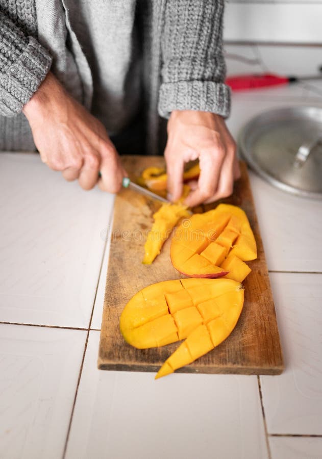 Unrecognizable Young Man is Chopping a Mango on the Cutting Board ...