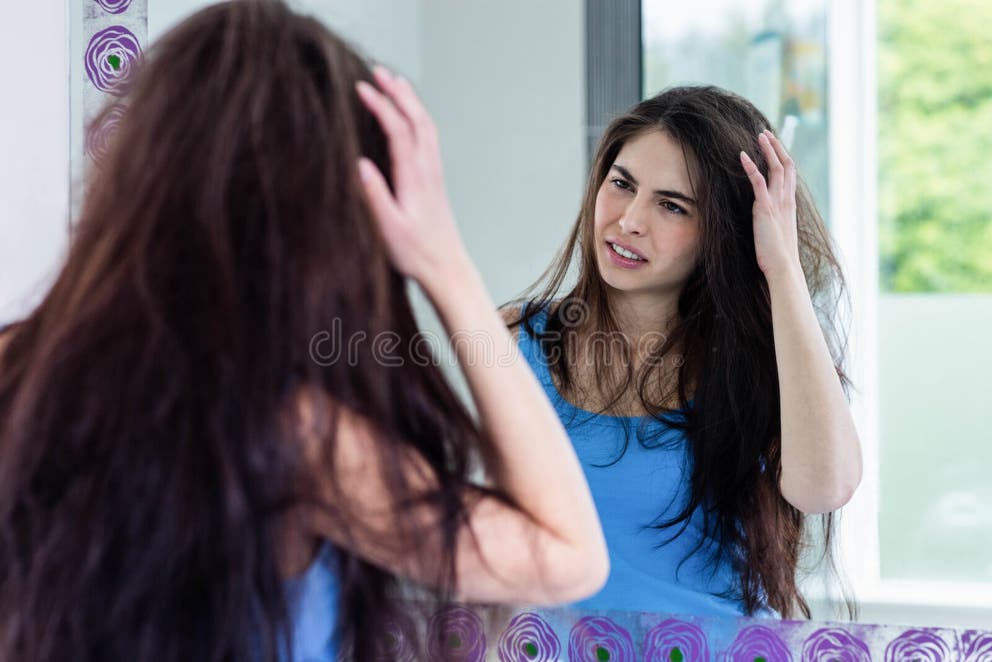 Unsmiling Brunette Looking Her Reflection in the Mirror Stock Photo ...