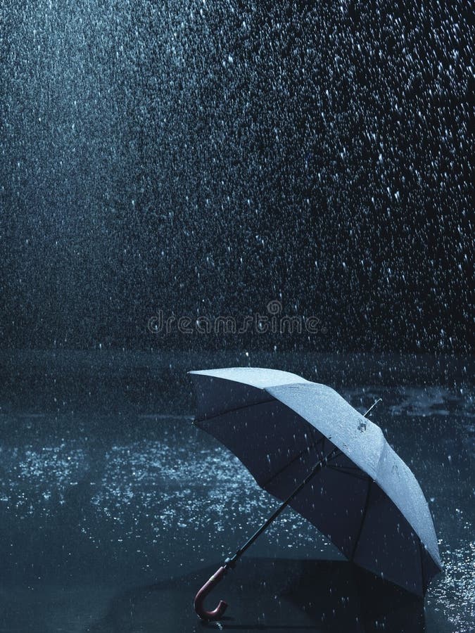 Unused Umbrella Lying on Ground Being Rained upon Stock Photo - Image ...