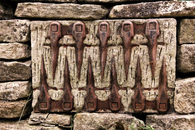 An Unusual Pattern of Old Farm Tools Set into a Stone Wall Stock Photo ...