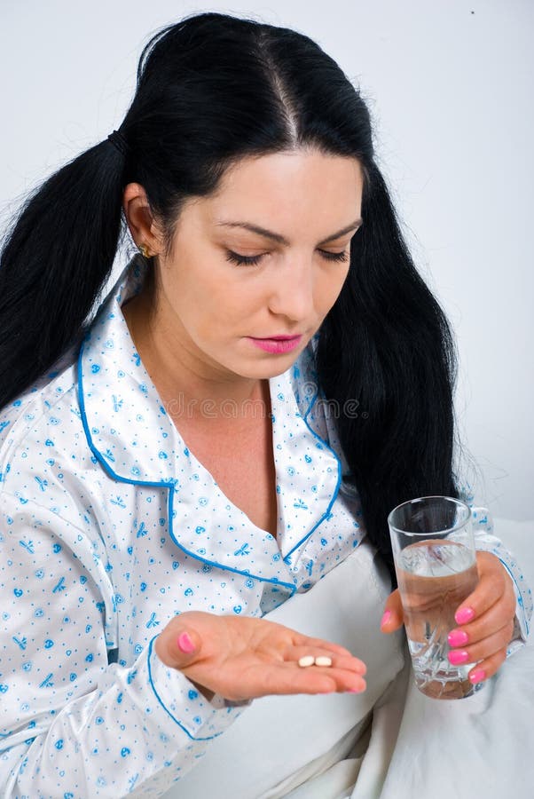 Unwell woman taking pills stock image. Image of bedroom - 14299885