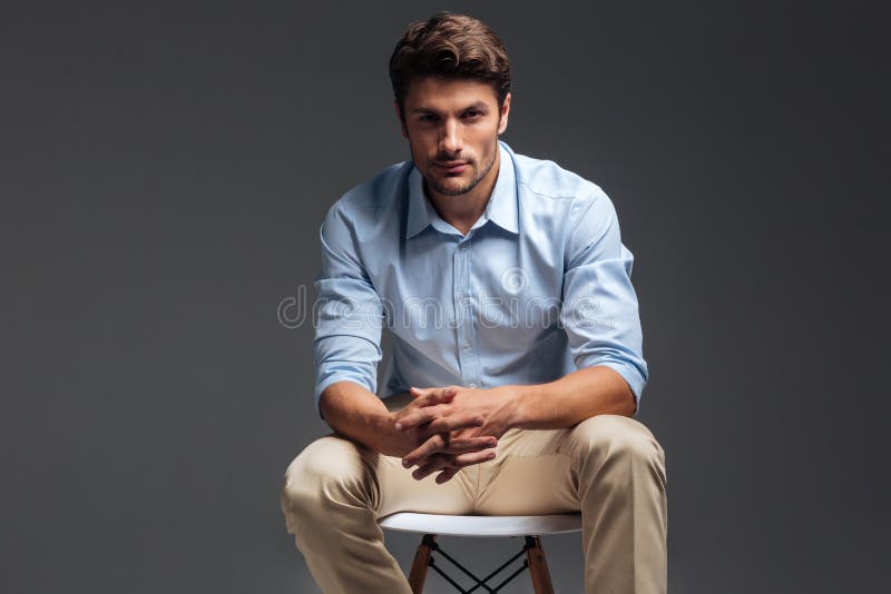 Uomo Bello Casuale Rilassato In Camicia Blu Che Si Siede Sulla Sedia