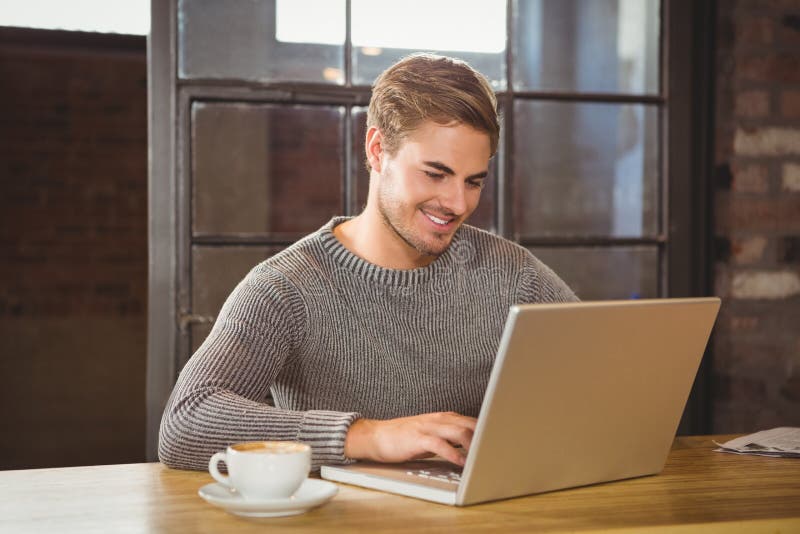 Uomo Bello Che Scrive Sul Suo Computer Portatile Mentre Sedendosi Sulla ...