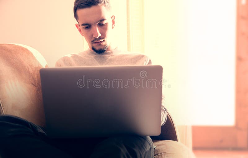 Uomo Che Utilizza Computer Portatile Nel Salone Immagine Stock ...