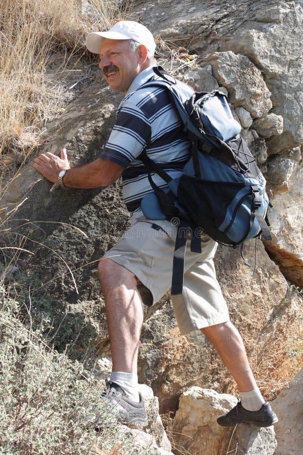 Uomo Maturo Che Scala Alta Roccia Che Rompe I Limiti Immagine Stock ...