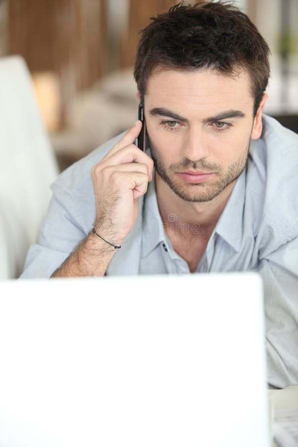 Uomo Serio Che Esamina Computer Portatile Fotografia Stock - Immagine ...