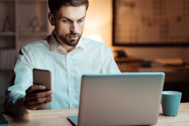 Uomo Serio Che Esamina Il Suo Computer Fotografia Stock - Immagine di ...