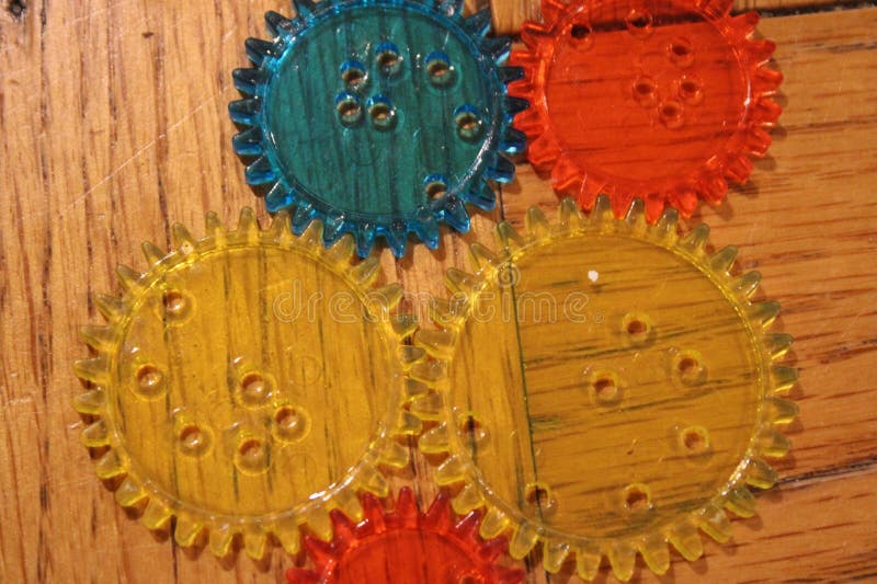 Plastic Multicoloured Gear Cogs, Wooden Table in Background Stock Image ...