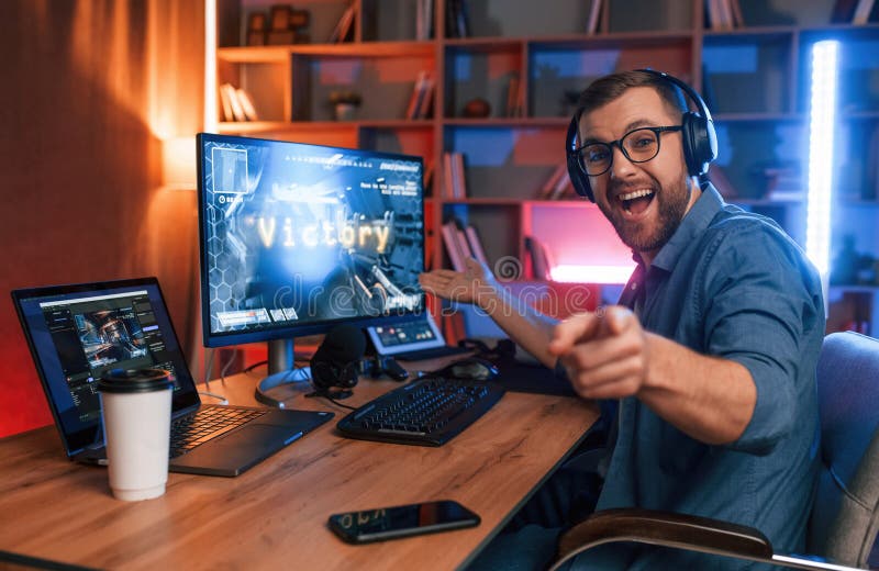 Uplifting and Energized Man is Playing the Shooter Game on His Computer ...