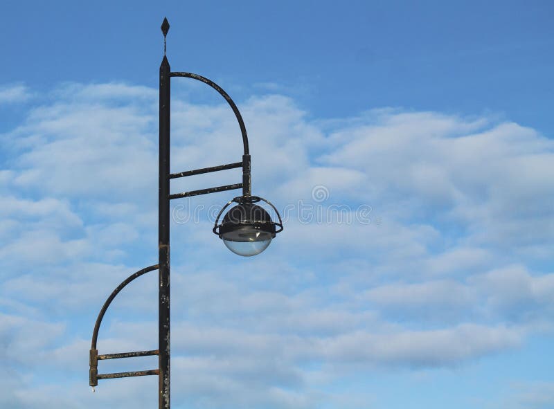 The Upper Part of the Pillar of a Street Lamp with a Canopy on a Blue ...