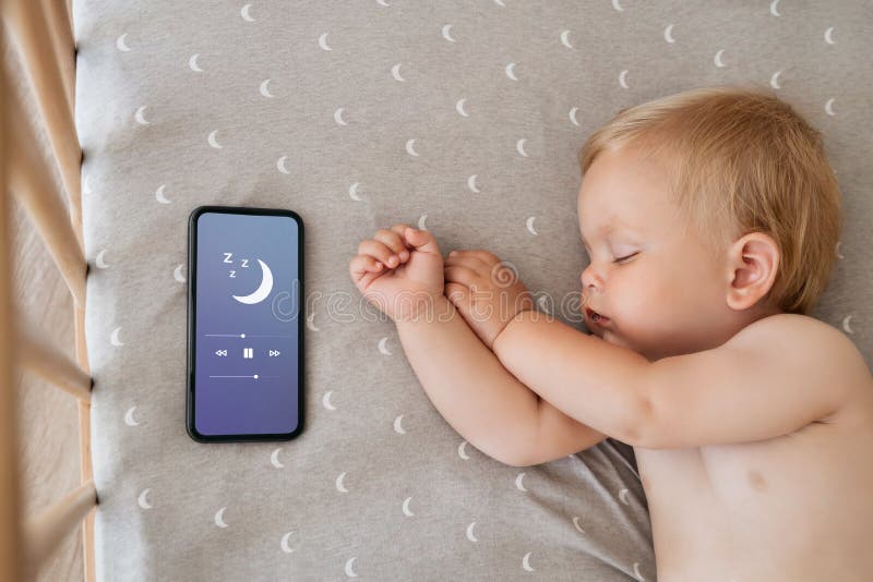 Upper View of Baby Napping in His Bed Next To Phone Playing Lullaby in ...