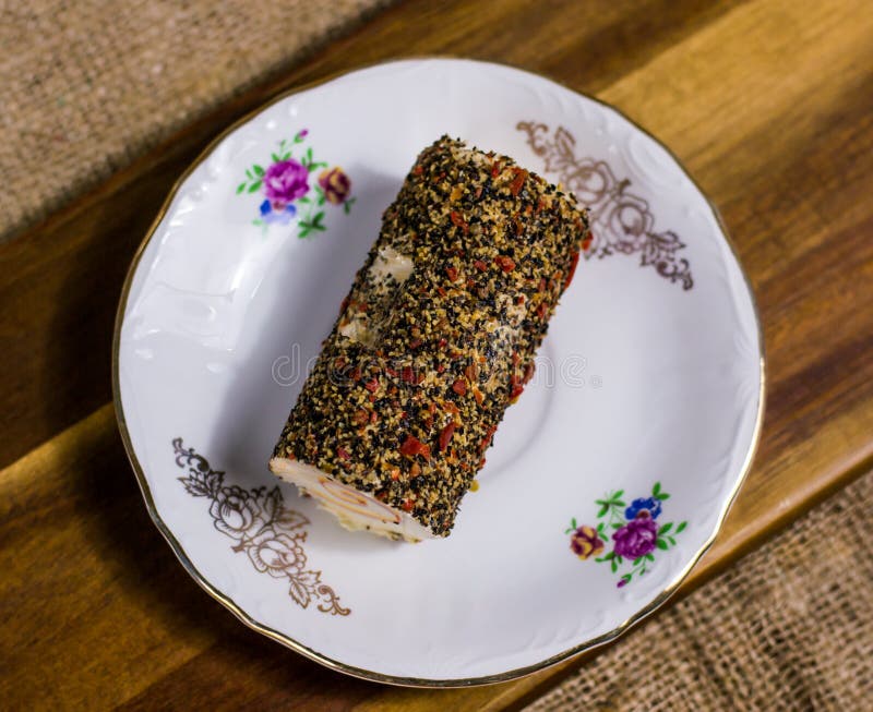 Upper View of a Cheese Roll with Spices on a White Decorated Plate and ...