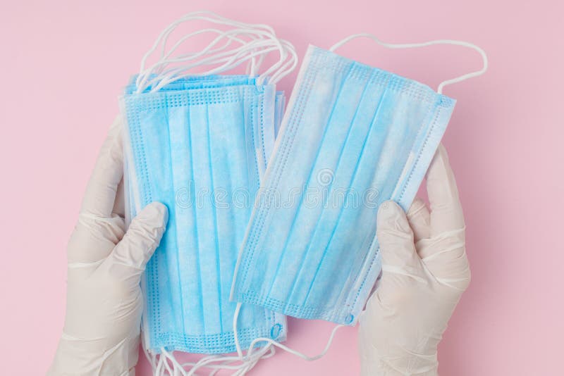 Upper View Of Hands In Rubber Gloves Holding Blue Medical Masks Stock