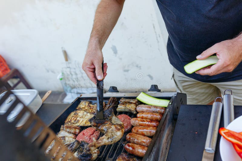 Upper View of Man Cooking Vegetables and Meat on a Grill in the Garden ...