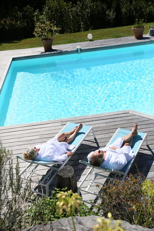 Upper View of Senior Couple Relaxing by the Swimming Pool Stock Image ...