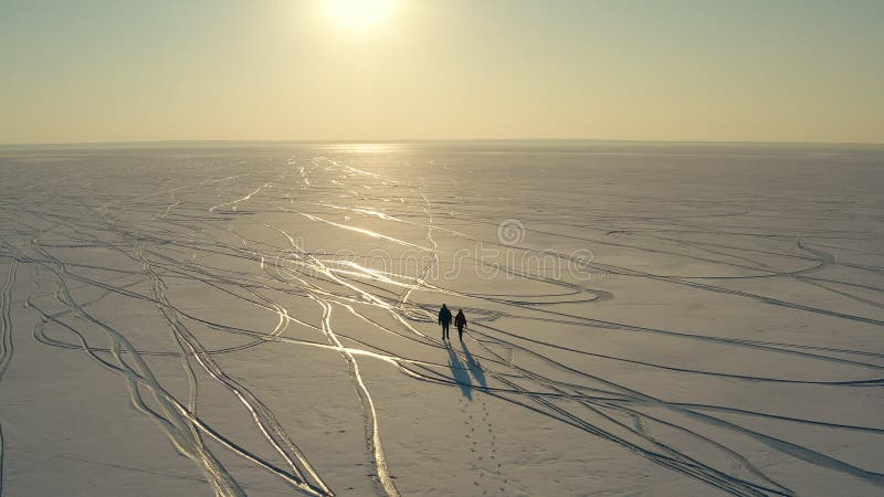 The Upper View on Two Tourists Trekking through the Icy Field. Stock ...