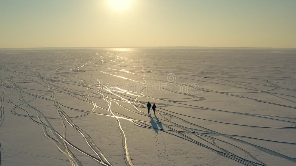 The Upper View on Two Tourists Trekking through the Icy Field. Stock ...