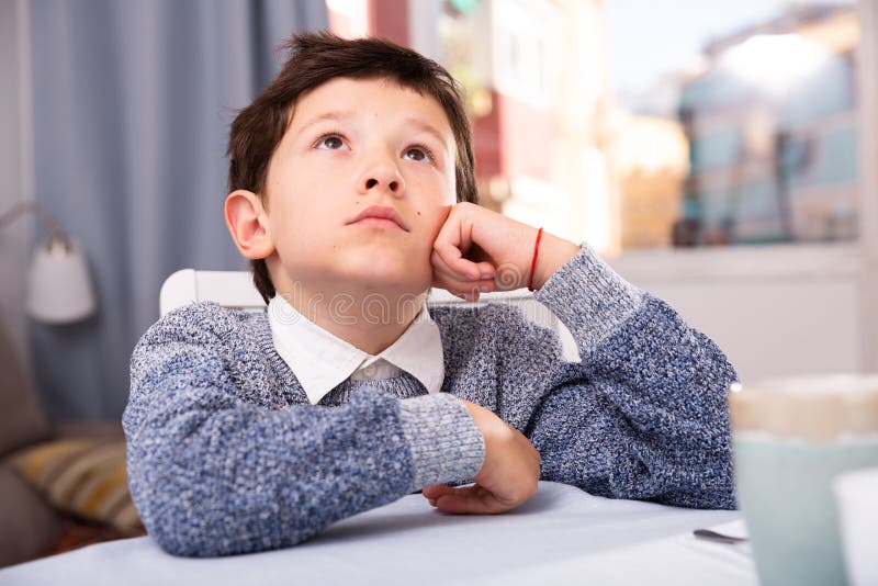 Upset Boy Sitting at Table and Thinks about Problems Stock Image ...