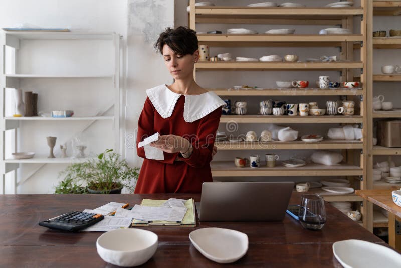 Upset Female Pottery Studio Owner Looking at Receipt with Worried ... Upset Female Pottery Studio Owner Looking at Receipt with Worried ...