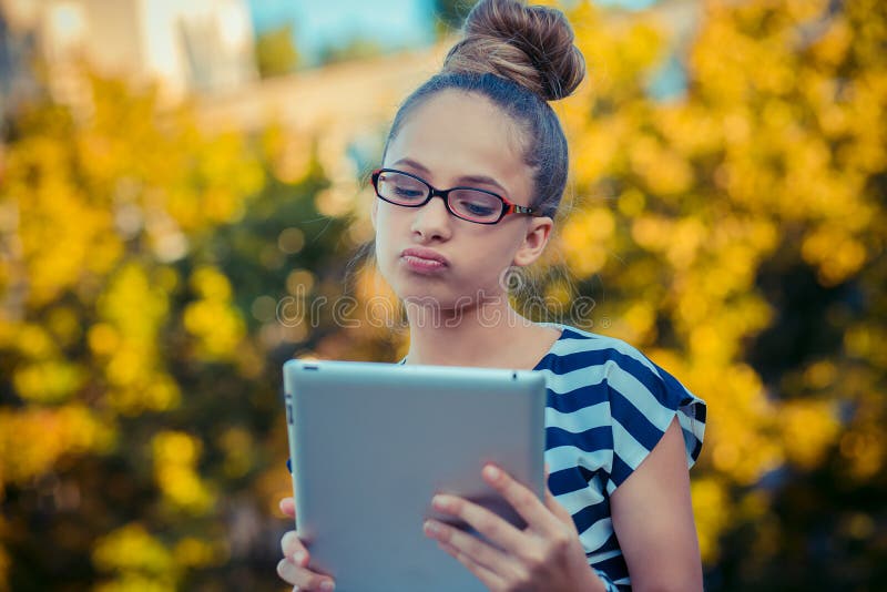 Upset Sad Skeptical Unhappy Serious Girl Using Mobile Pad Computer ... Upset Sad Skeptical Unhappy Serious Girl Using Mobile Pad Computer ...