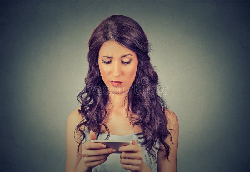 Sad Skeptical Unhappy Woman Texting On Phone Outdoors In Park Stock