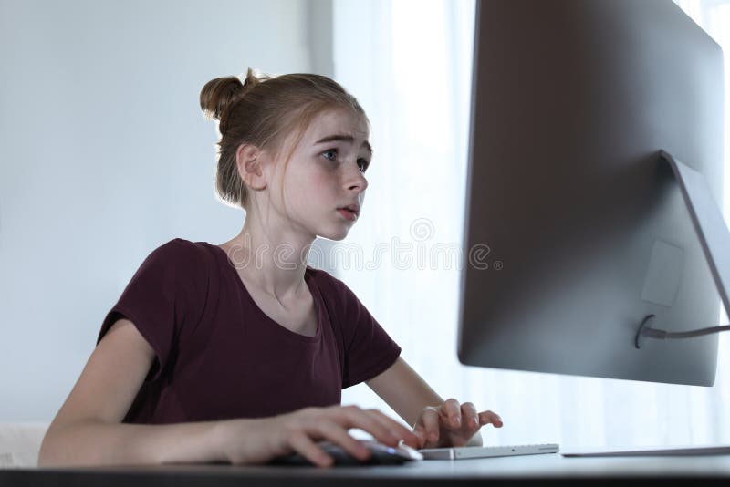 Upset Teenage Girl Using Computer at Table. Danger of Internet Stock ...