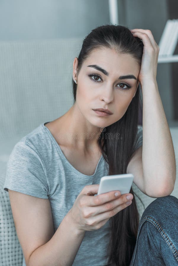 Upset Young Woman Holding Smartphone and Looking Stock Photo - Image of ...