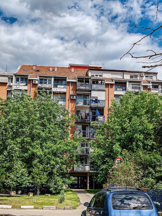 Urban Apartment Building Surrounded by Lush Trees Under a Vibrant Sky ...