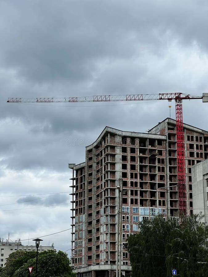 Urban Construction Site with Crane Against Cloudy Sky during Building ...