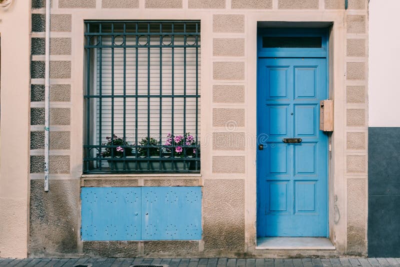 Urban Facade with Blue Door and Grilled Window Stock Photo - Image of ...