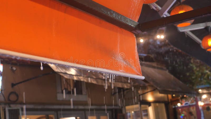 The Urban Rainfall Creates a Captivating Scene Beneath a Bright Orange ...