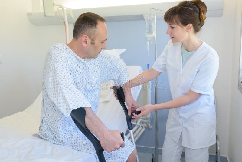 Urse Ayuda Al Paciente a Levantarse En Hospital Imagen de archivo ...