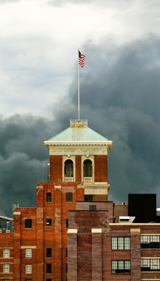US Flag Waves Above a Building As Smoke from a Fire Passes Behind Stock ...