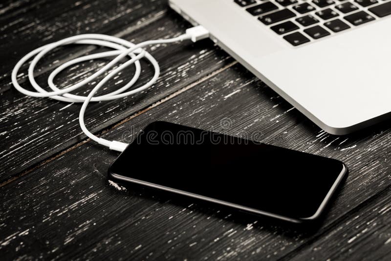 A USB Cable Connects Your Phone and Laptop. on the Black Table Stock ...