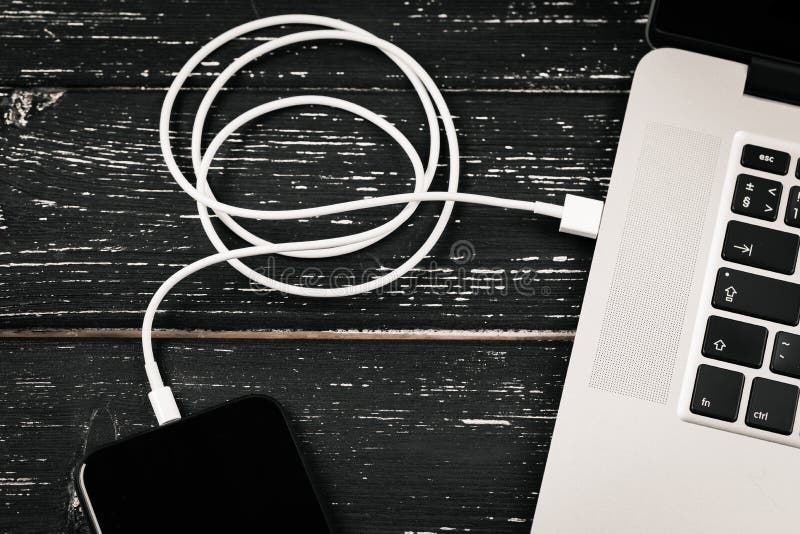 A USB Cable Connects Your Phone and Laptop. on the Black Table Stock ...