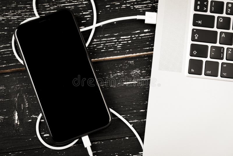 A USB Cable Connects Your Phone and Laptop. on the Black Table Stock ...