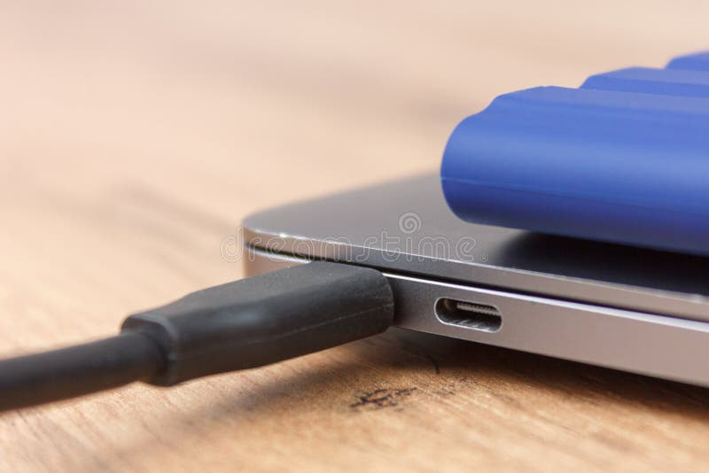 USB Cable Plugged into a Laptop on a Wooden Desk. Stock Photo - Image ...