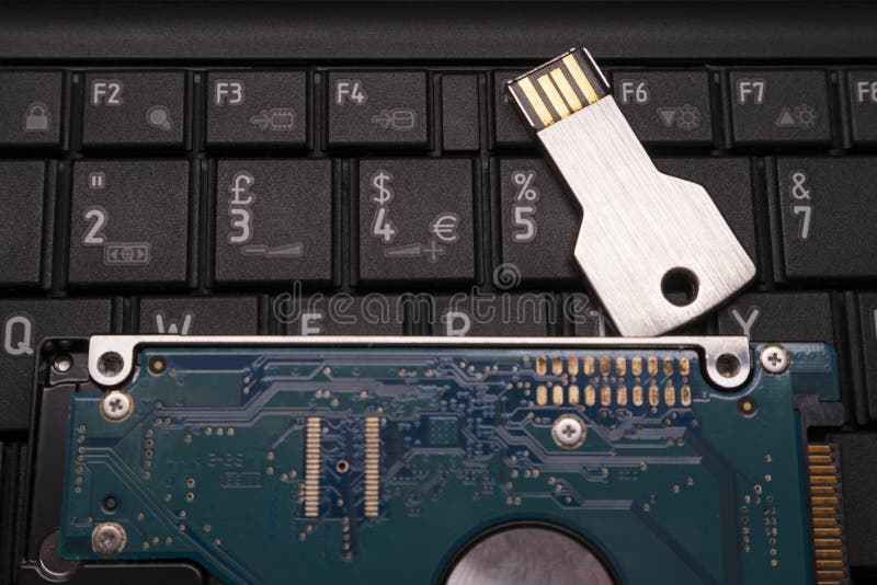 USB Flash Drive in the Form of a Metal Key. Blurred Hard Disk and ...