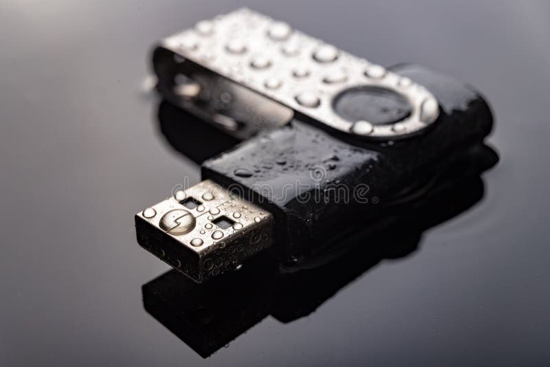 USB Flash Drive with Water Drops on the Table. Electronic Data Storage ...
