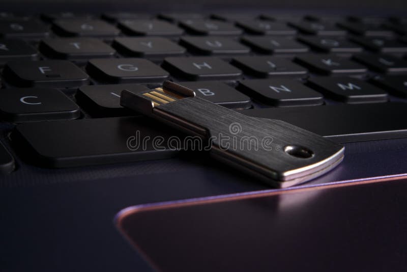 USB Memory Stick in the Form of a Key on a Laptop Keyboard Close-up ...