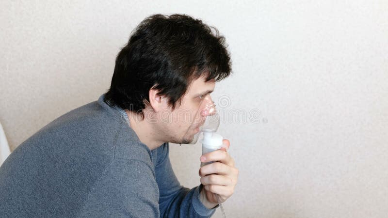 Use Nebulizer and Inhaler for the Treatment. Young Man Inhaling through ...