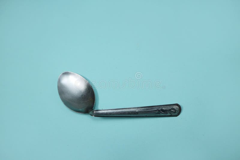 A Used and Bent Spoon, Isolated on a Blue Background. Stock Image ...