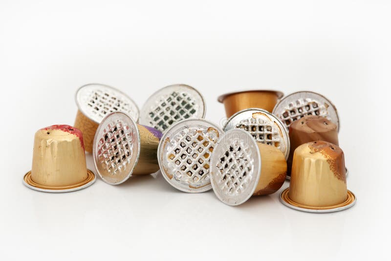 Used Coffee Capsules in Various Metallic Colors Scattered on a White ...