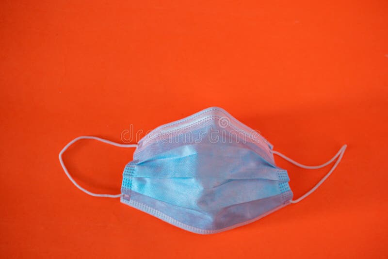 A Used Mask on an Orange Background Stock Photo - Image of pandemic ...