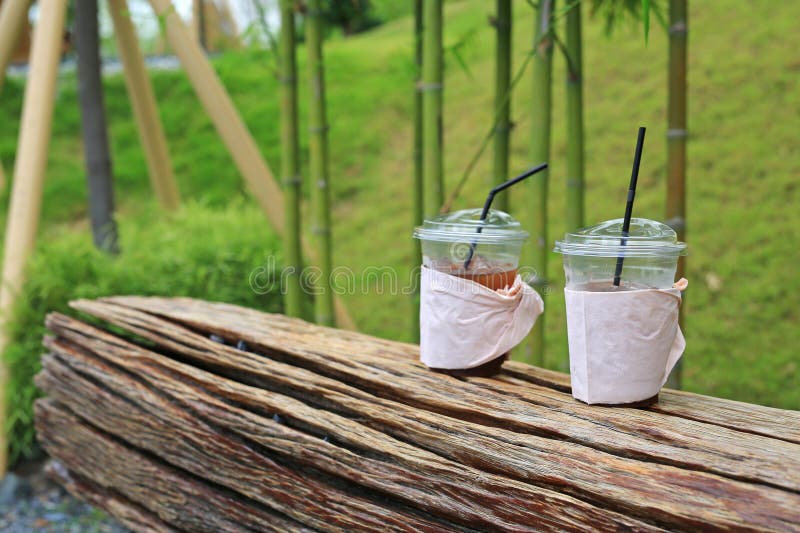 A Used Plastic Drink Cups is Placed on a Wooden Bench in the Garden ...