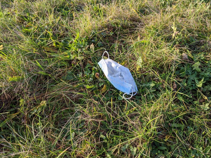 Used Protective Face Mask Discarded on a Grassy Ground Stock Photo ...